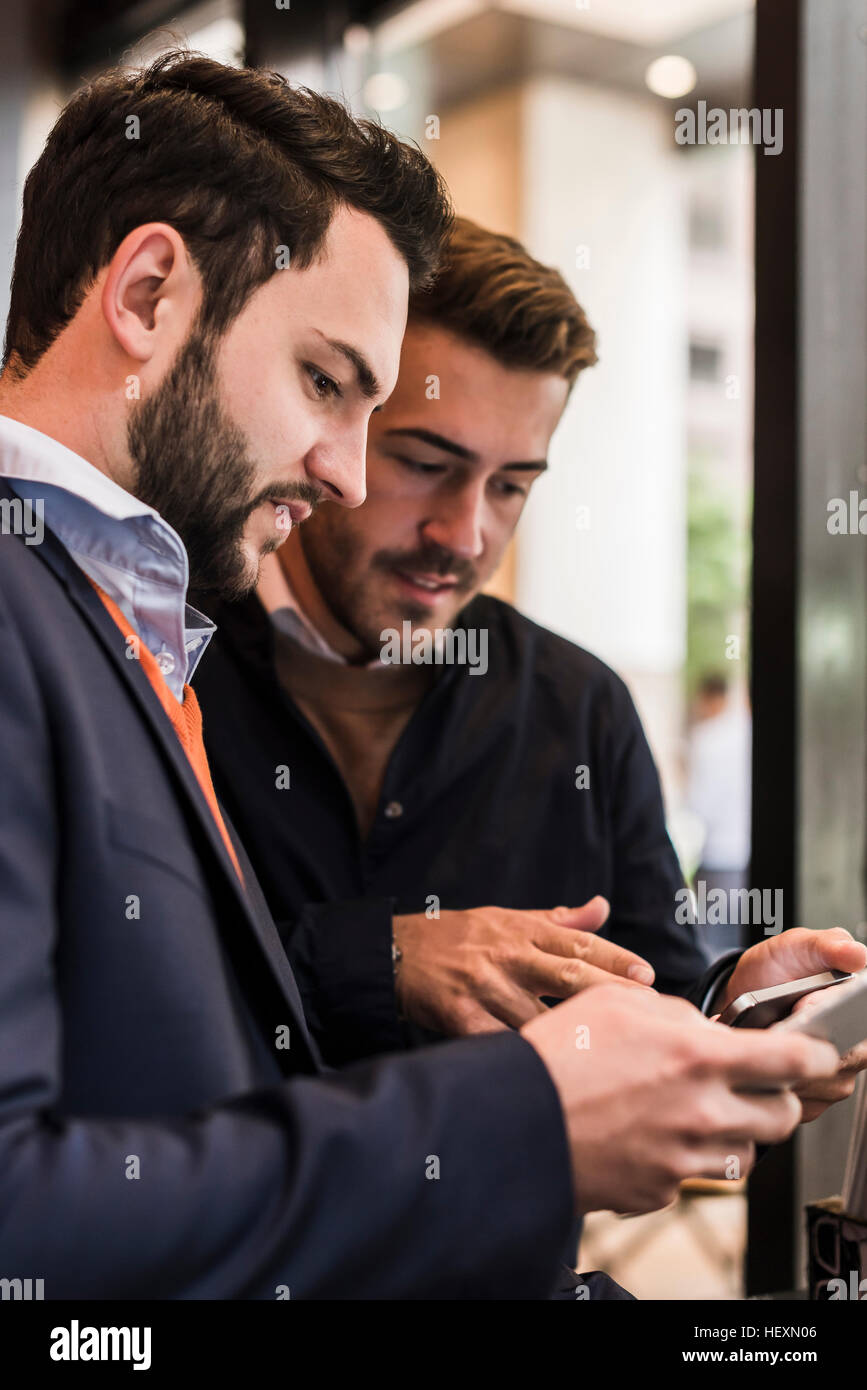 USA, New York City, Businessmen checking mobile devices Stock Photo - Alamy