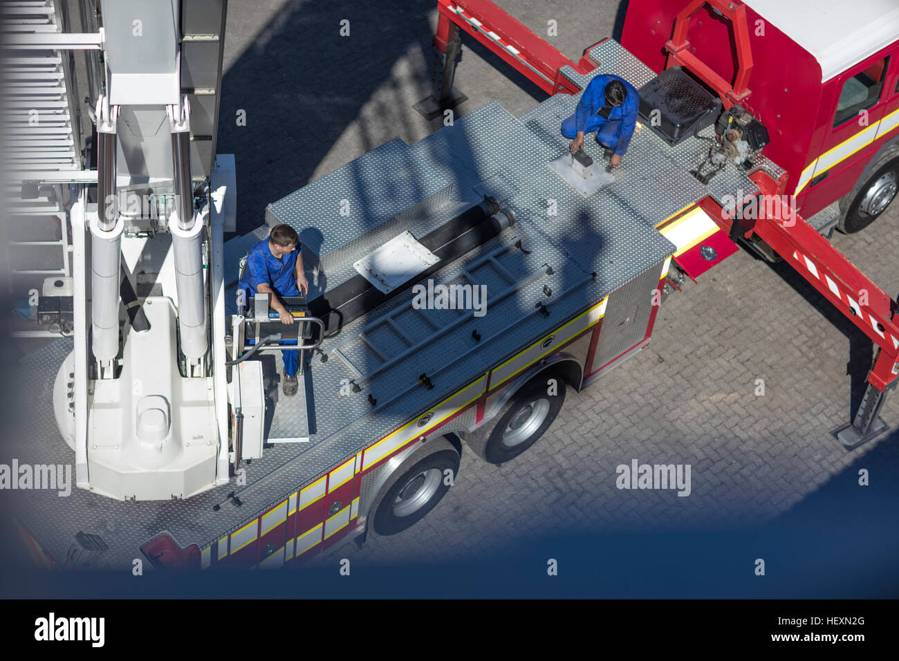 Mechanics maintaining fire engine Stock Photo - Alamy