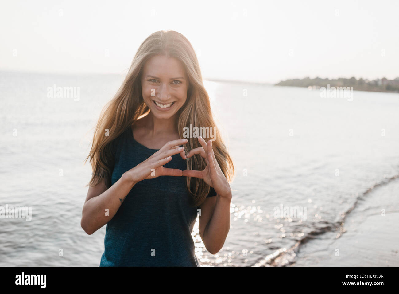 Portrait of happy young woman at seafront Stock Photo - Alamy