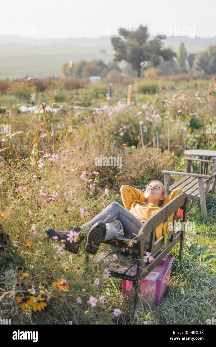 Young woman relaxing in cottage garden Stock Photo - Alamy
