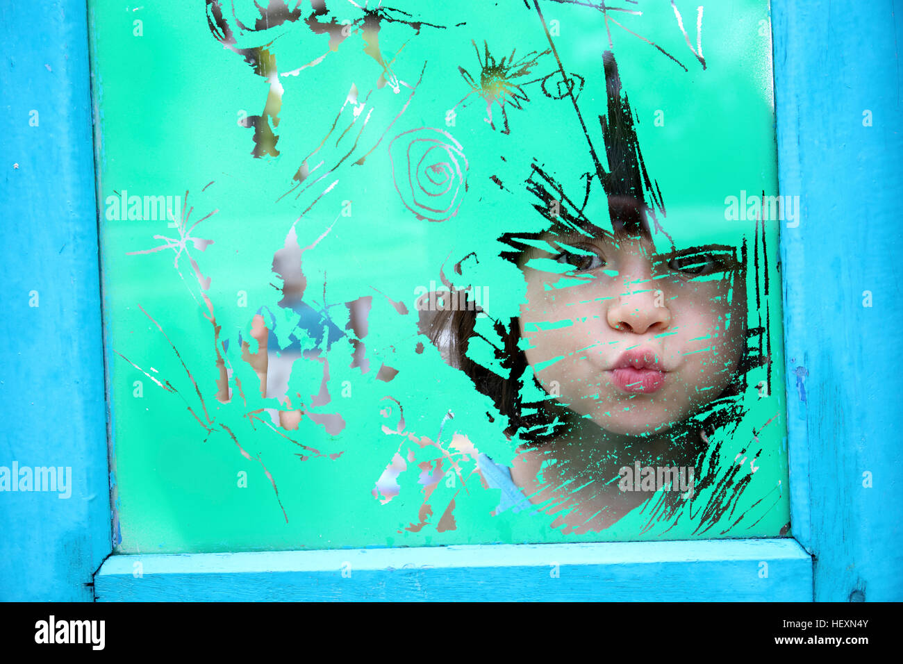 Girl looking through the glass of an old window Stock Photo - Alamy