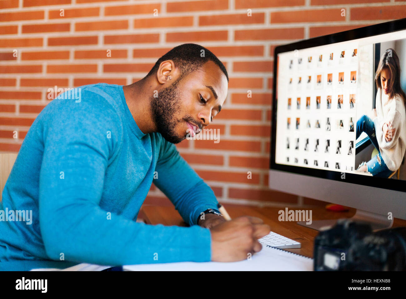 Young photographer editing images at desk Stock Photo - Alamy