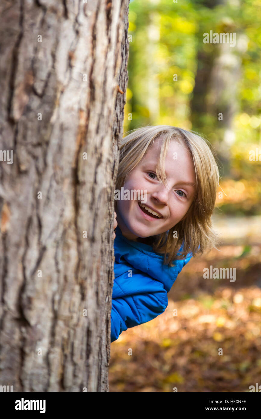 Boy hiding behind tree in hi-res stock photography and images - Alamy