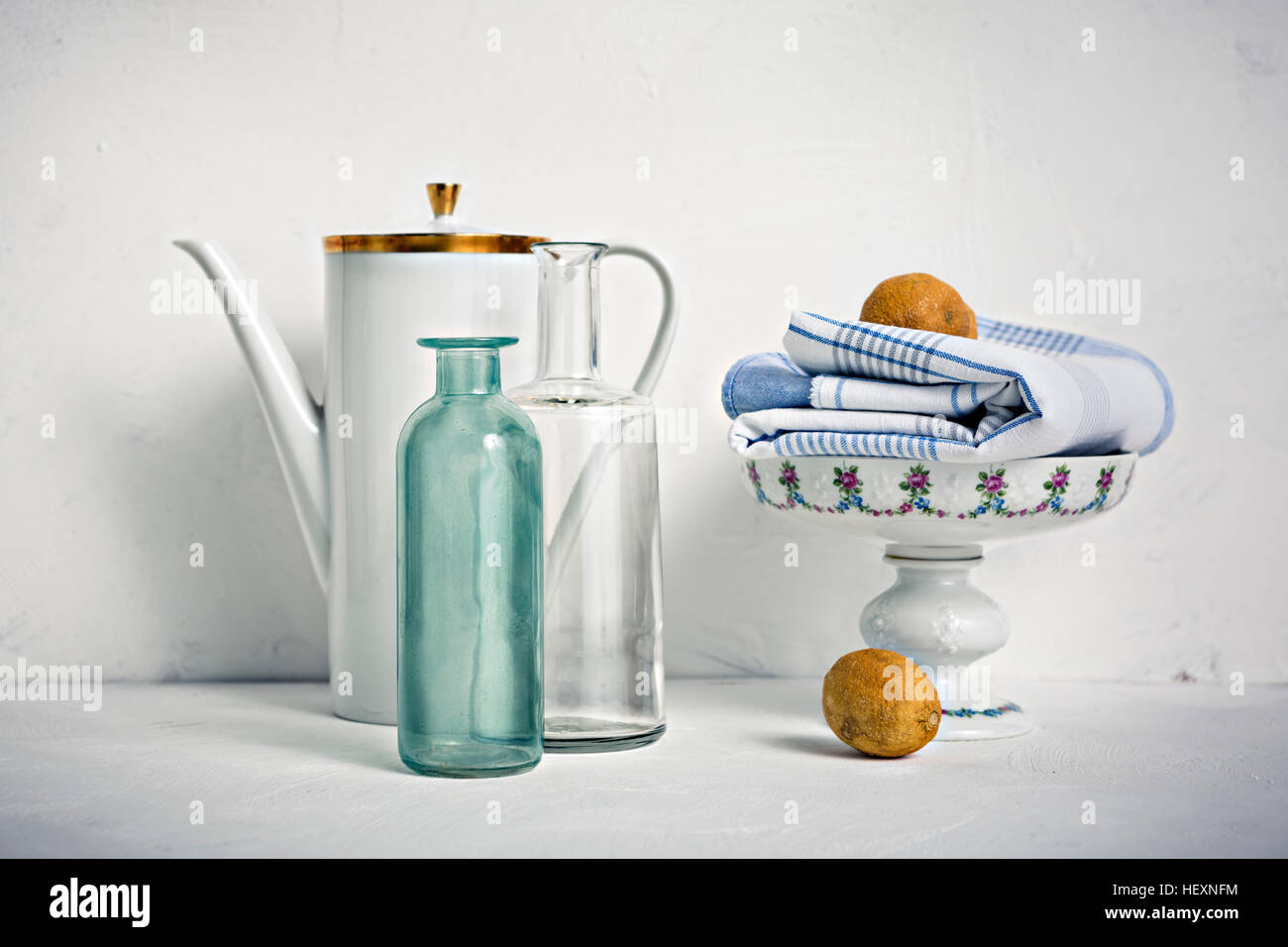 Still life with coffee pot, glass bottles, bowl, towel and lemons Stock ...