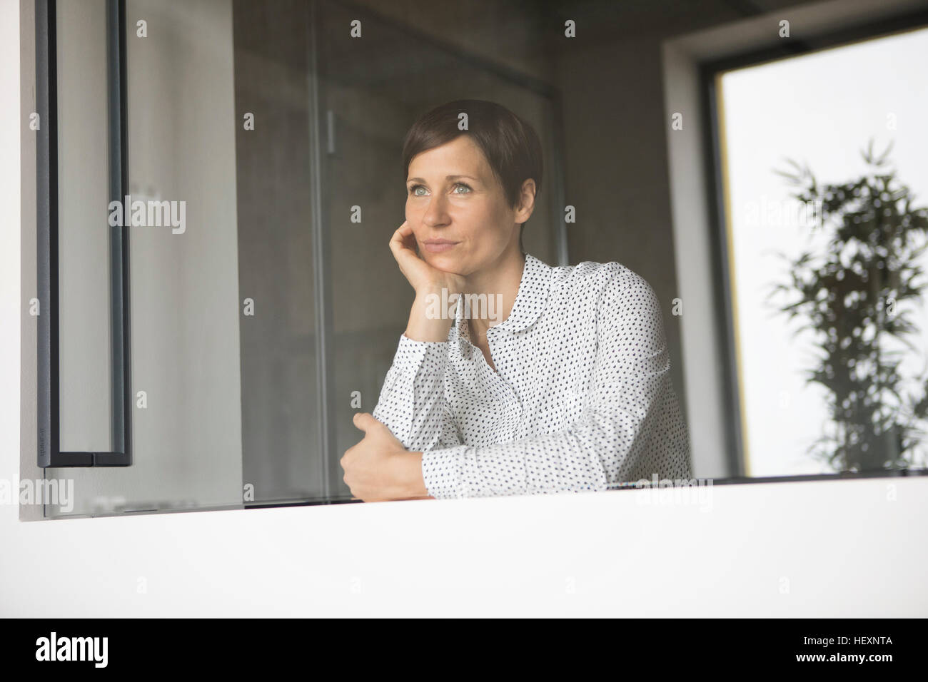 Woman looking out of window Stock Photo - Alamy