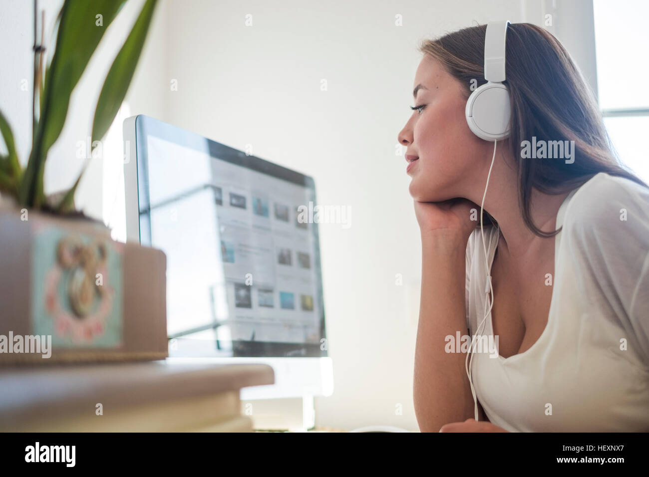 Young woman with headphones at computer Stock Photo - Alamy