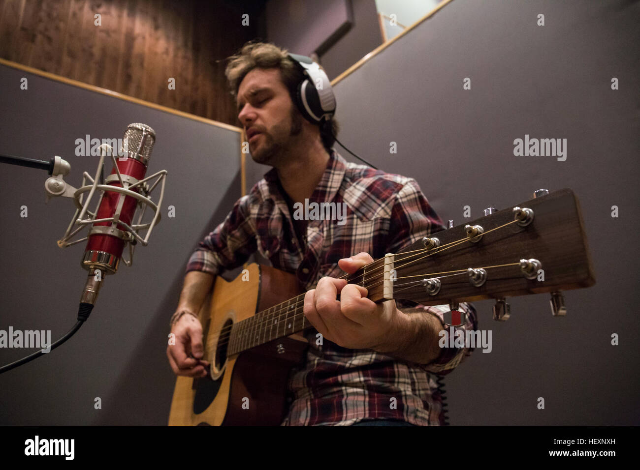 Man playing guitar in a recording studio during a musical recording ...