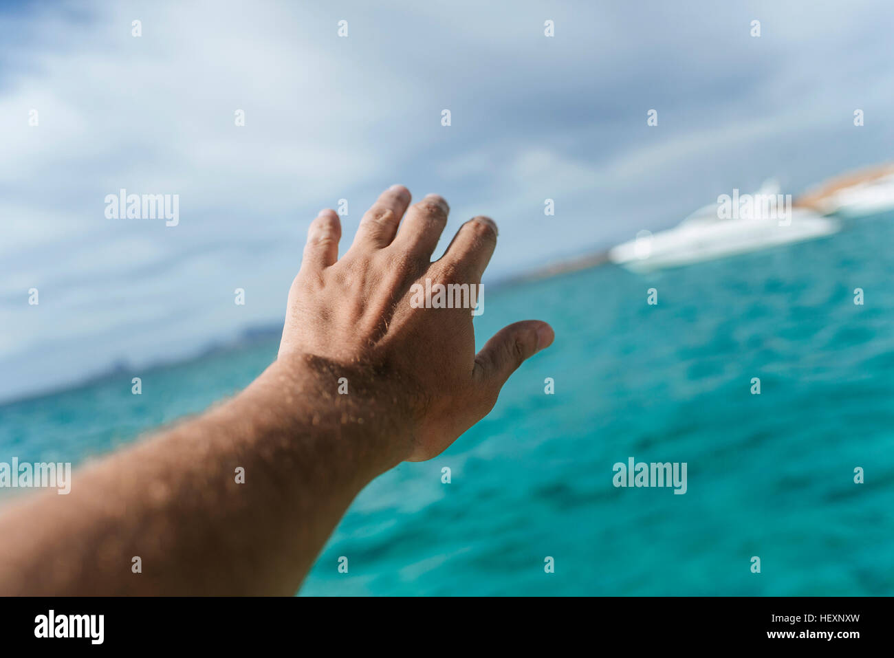 Hand reaching out for distant motor boat Stock Photo - Alamy