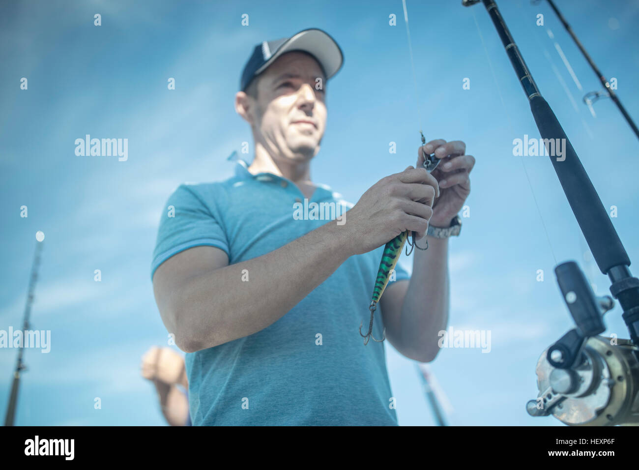 Man applying bait on fishing rod Stock Photo - Alamy