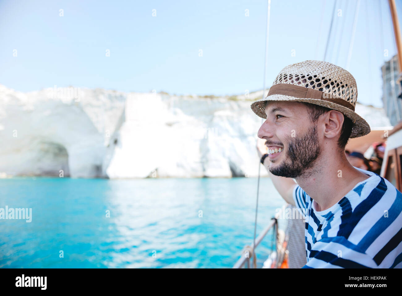 Greece, Milos, Man with straw hat on sailing boat Stock Photo - Alamy