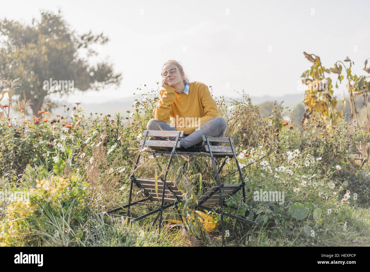 Young woman relaxing in cottage garden Stock Photo - Alamy