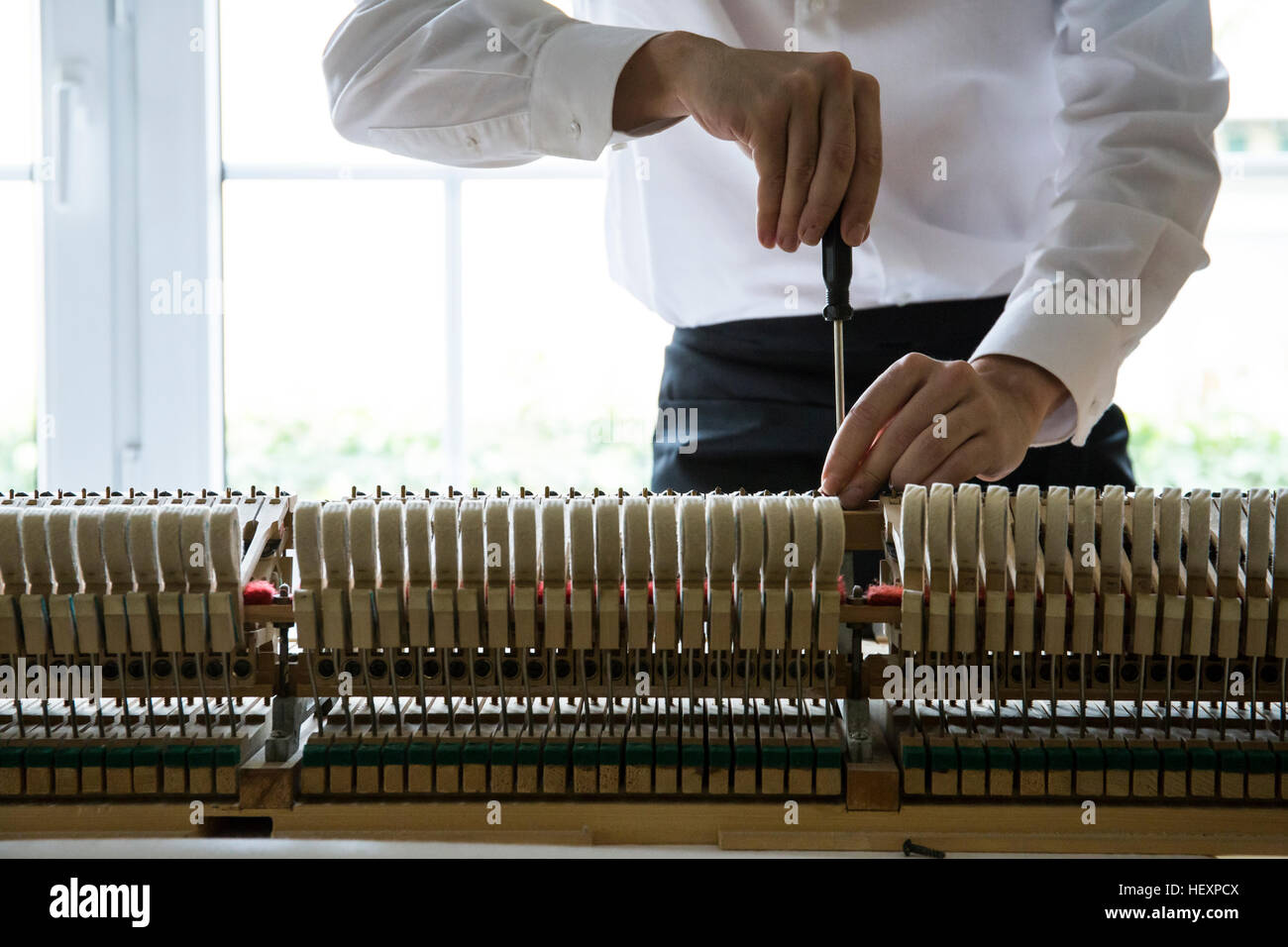 Piano tuner tuning grand piano Stock Photo - Alamy