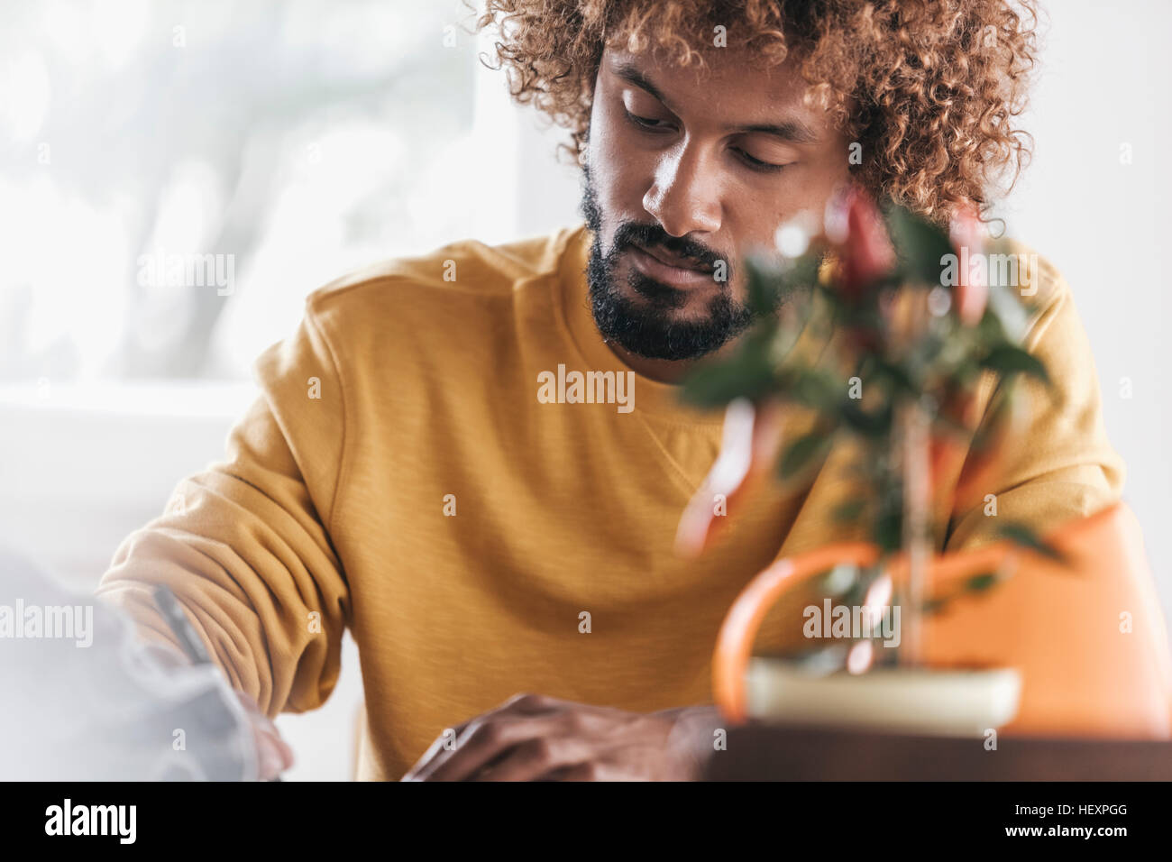 Young man looking down, writing Stock Photo - Alamy