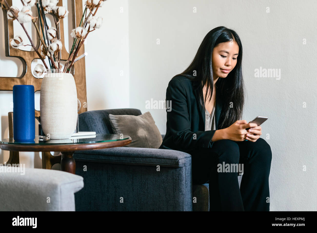 Businesswoman sitting in lounge using smart phone Stock Photo - Alamy