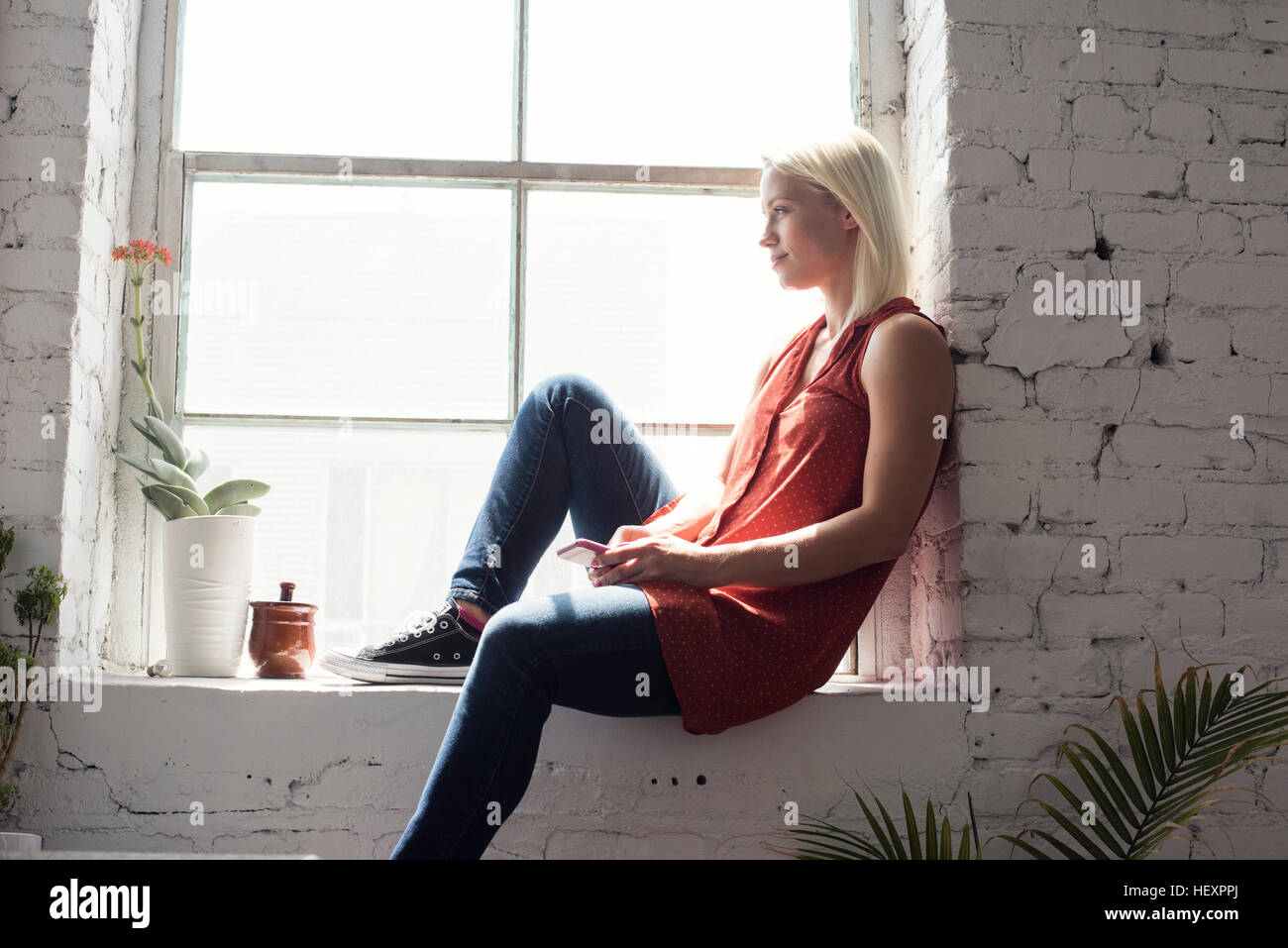 Woman leaning on windowsill hi-res stock photography and images - Alamy