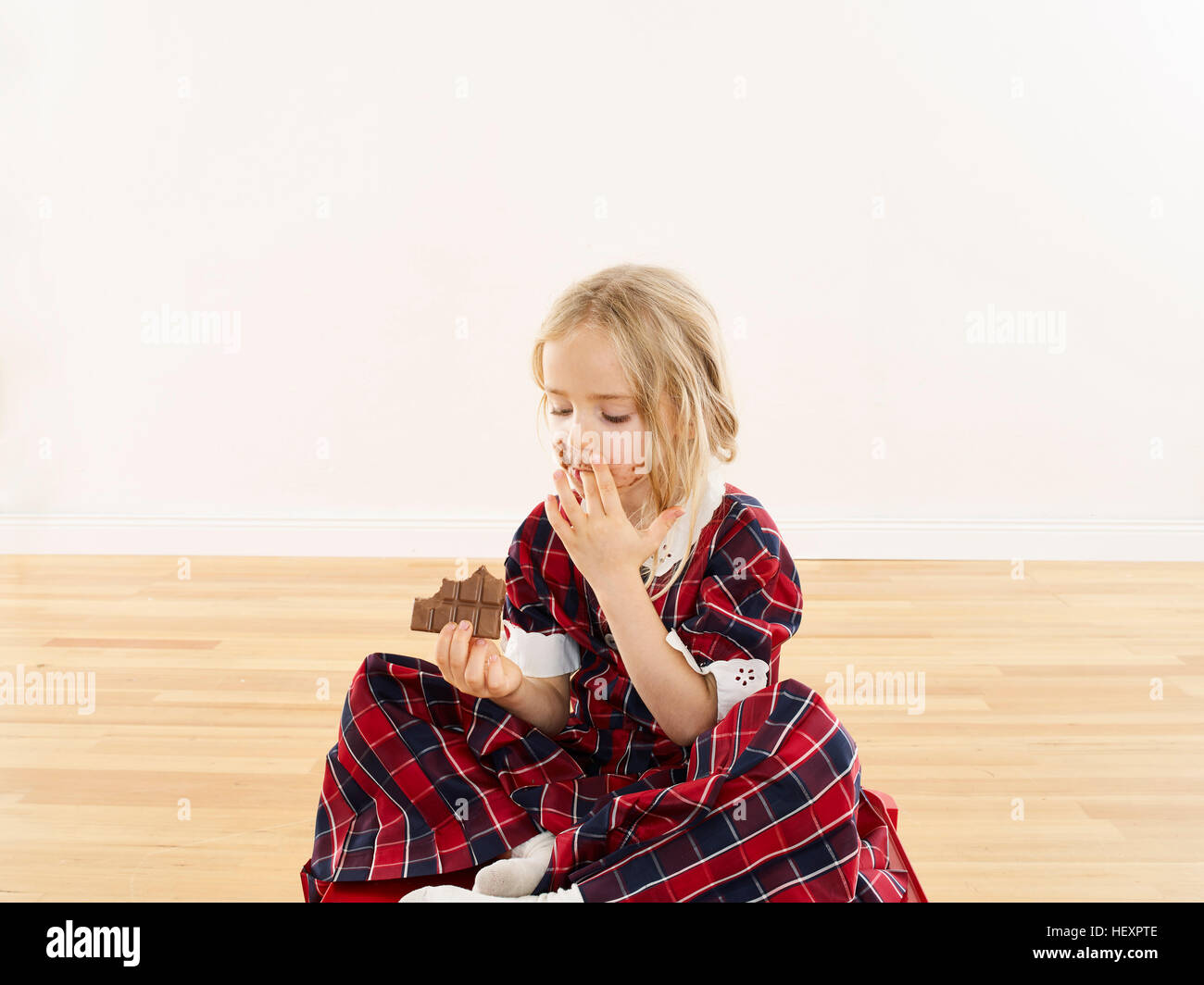 Little girl eating chocolate Stock Photo - Alamy