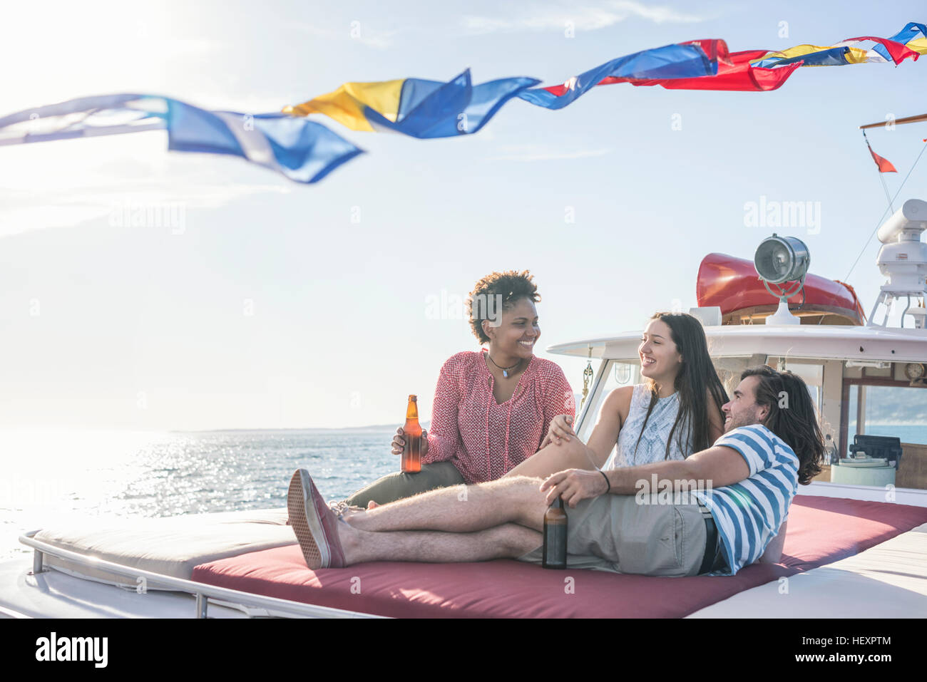 Happy friends on a boat trip having a beer Stock Photo - Alamy