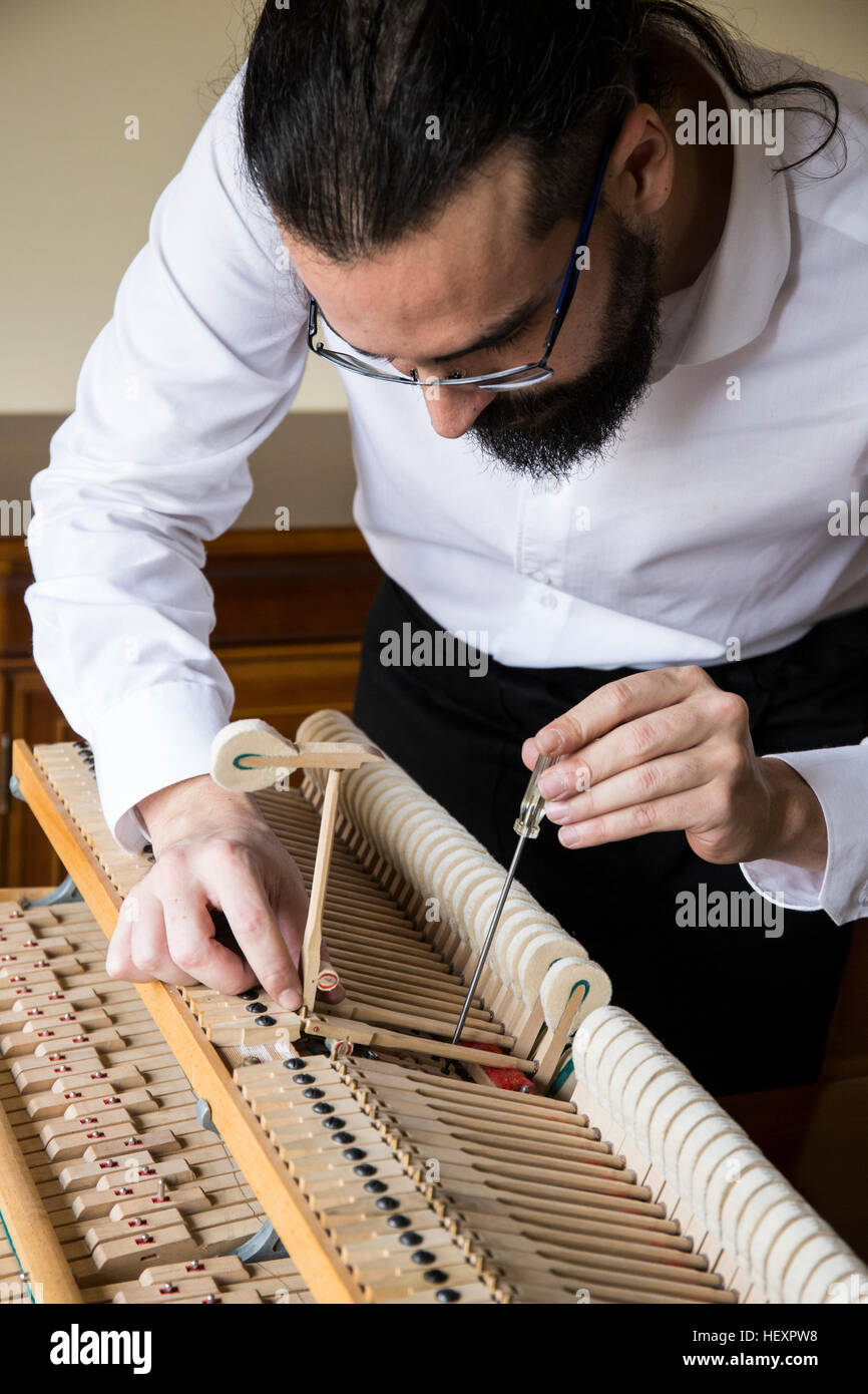 Piano tuner tuning grand piano Stock Photo - Alamy