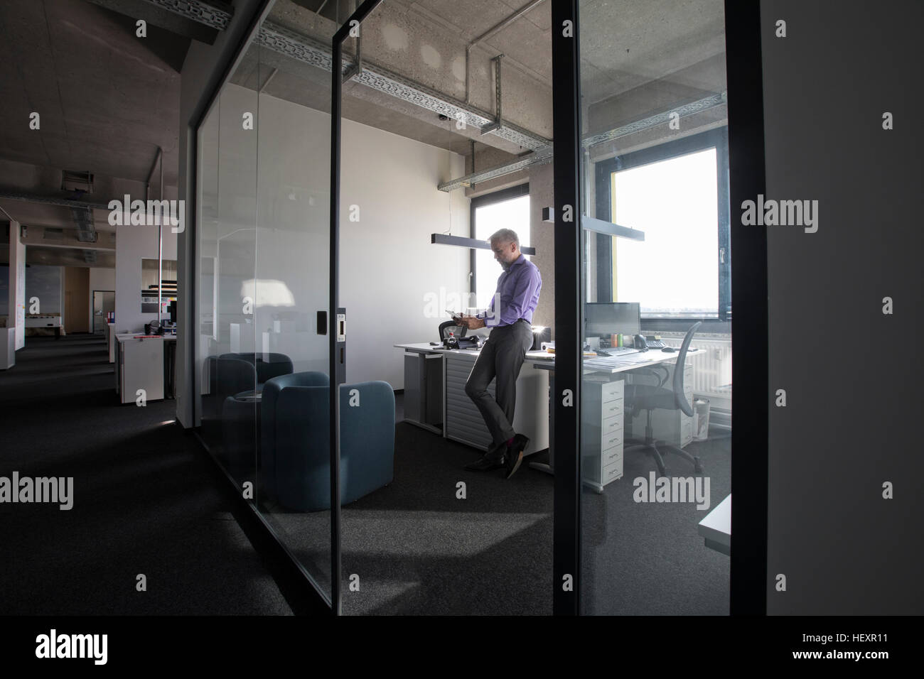 Businessman alone in office Stock Photo - Alamy