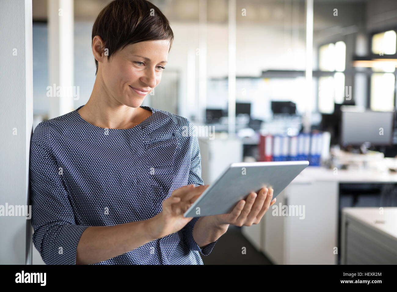 Businesswoman in office using tablet Stock Photo - Alamy