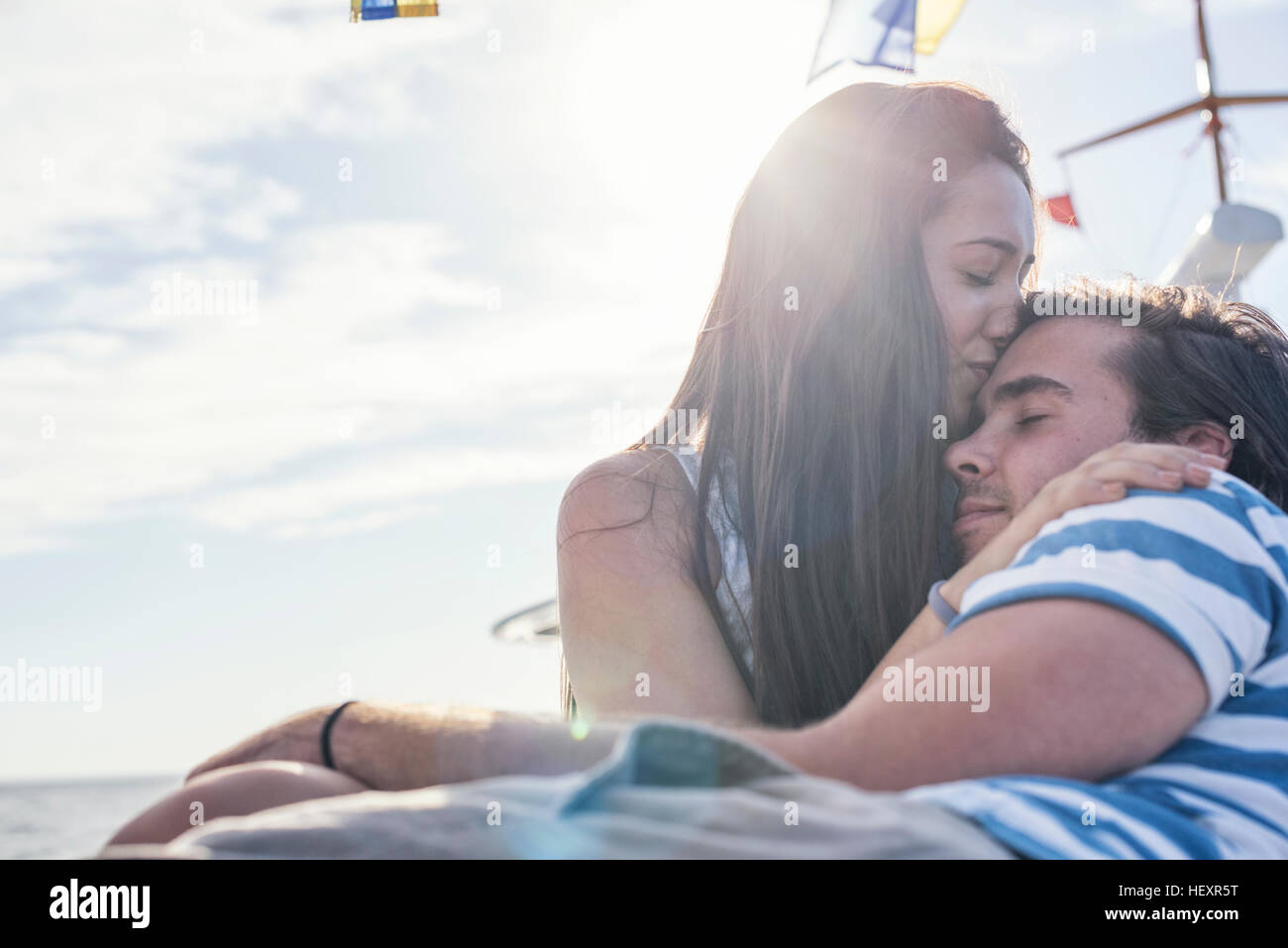 Young couple cuddling on a boat trip Stock Photo - Alamy