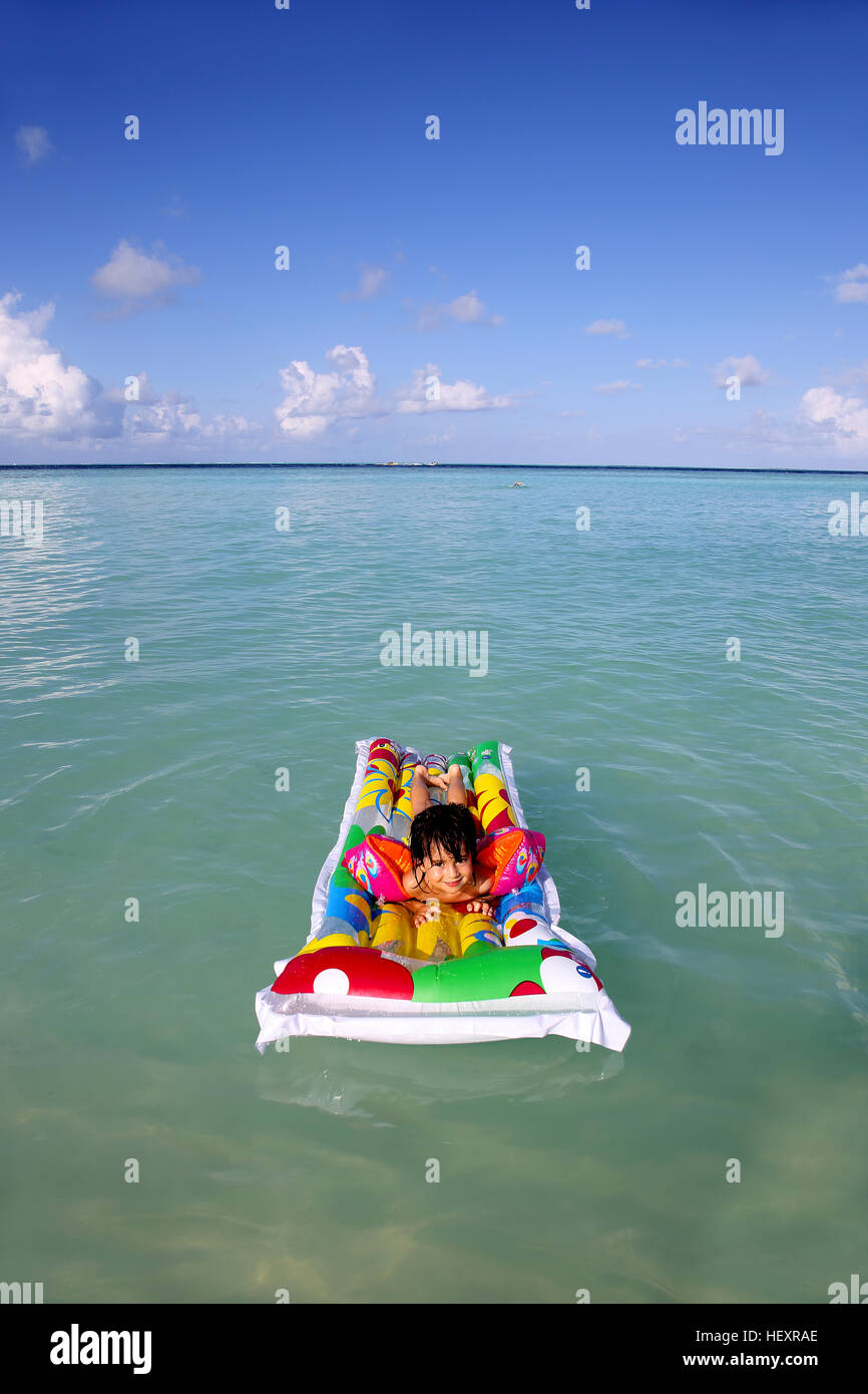 Maldives, Gulhi, girl floating on inflatable airbed in water Stock ...