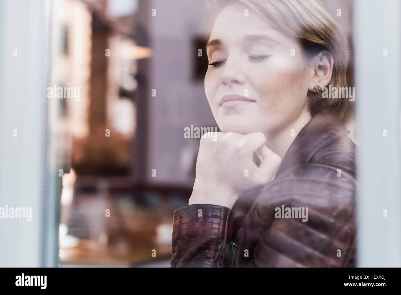Young woman with closed eyes behind windowpane Stock Photo - Alamy