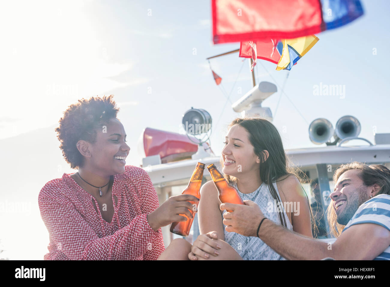 Happy friends on a boat trip having a beer Stock Photo - Alamy