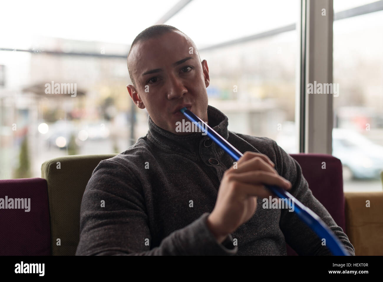 Young Man Smoking Shisha Outdoors - Man Exhaling Smoke Inhaling From A ...
