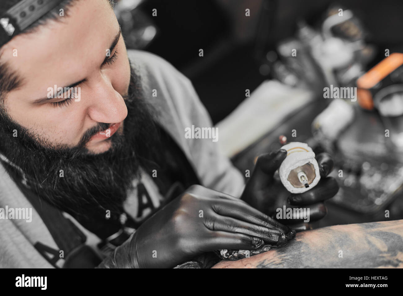 Tattoo master is tattooing in the tattoosalon Stock Photo - Alamy