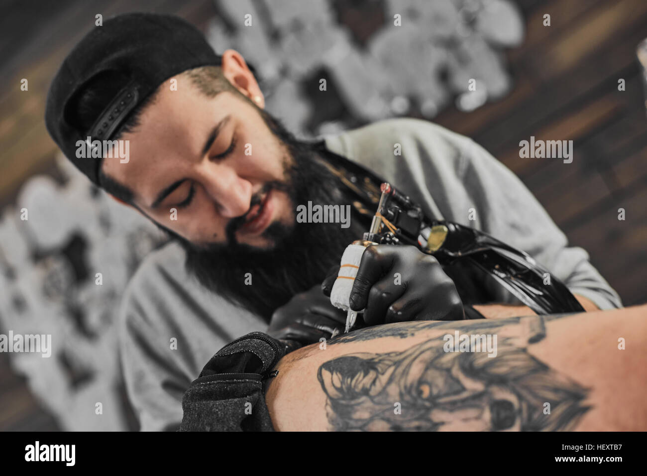 Tattoo master is tattooing in the tattoosalon Stock Photo - Alamy