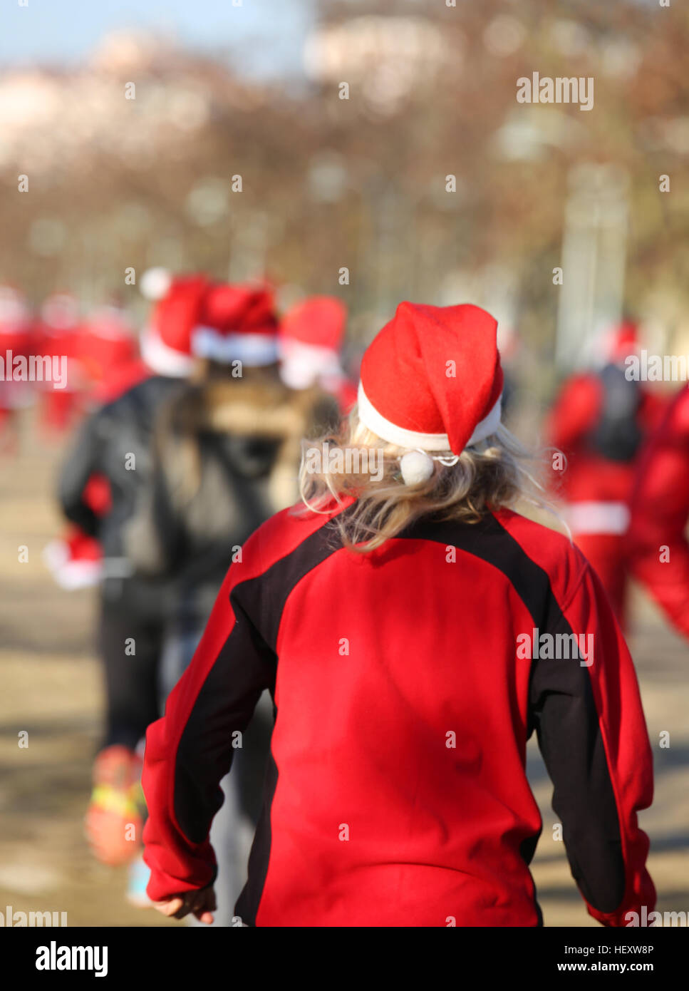 woman with blond hair running during the run of Santas at Christmas ...