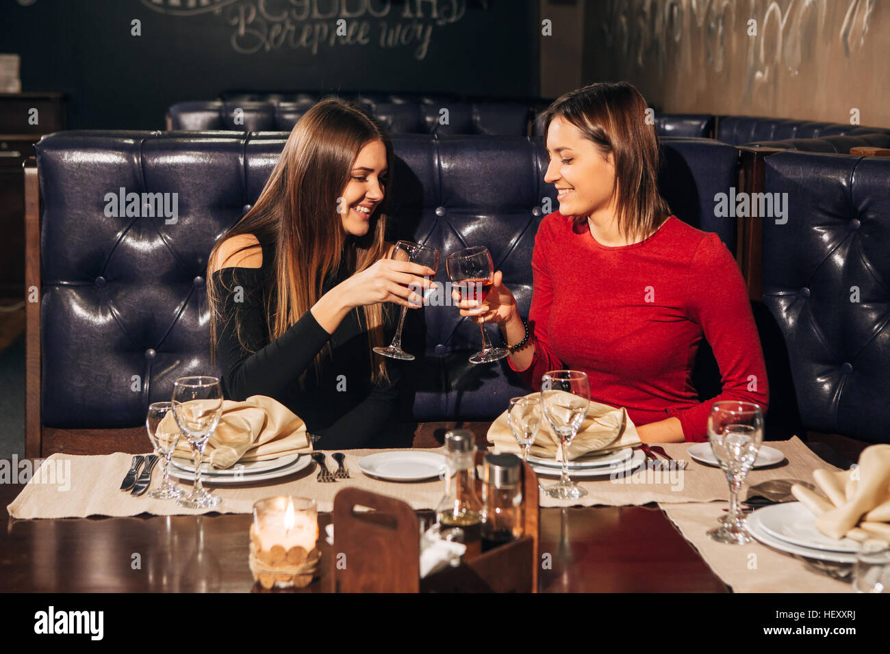 two women drink wine in a restaurant Stock Photo - Alamy