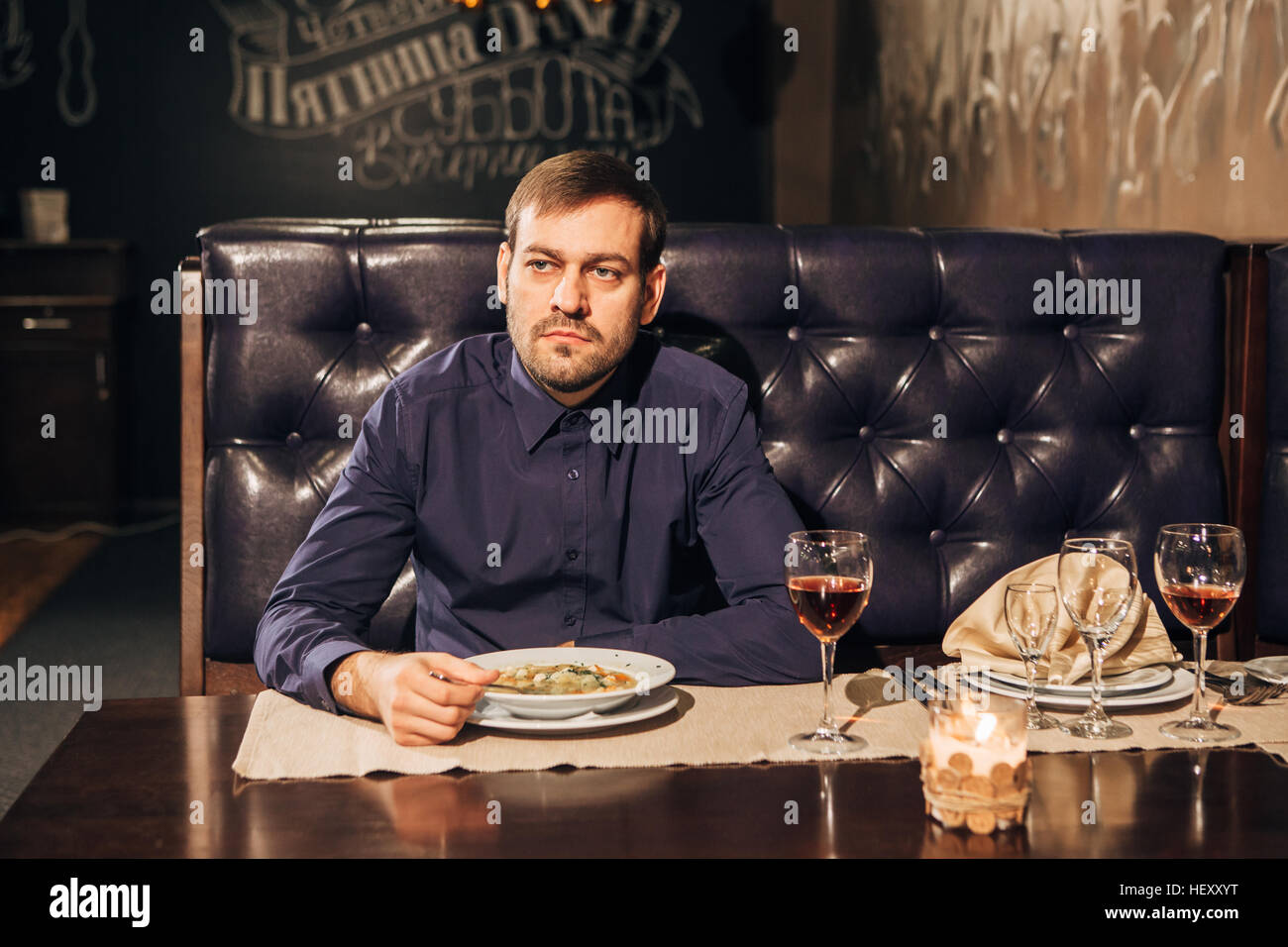 serious man eats in the restaurant and drinks wine with lunch Stock ...