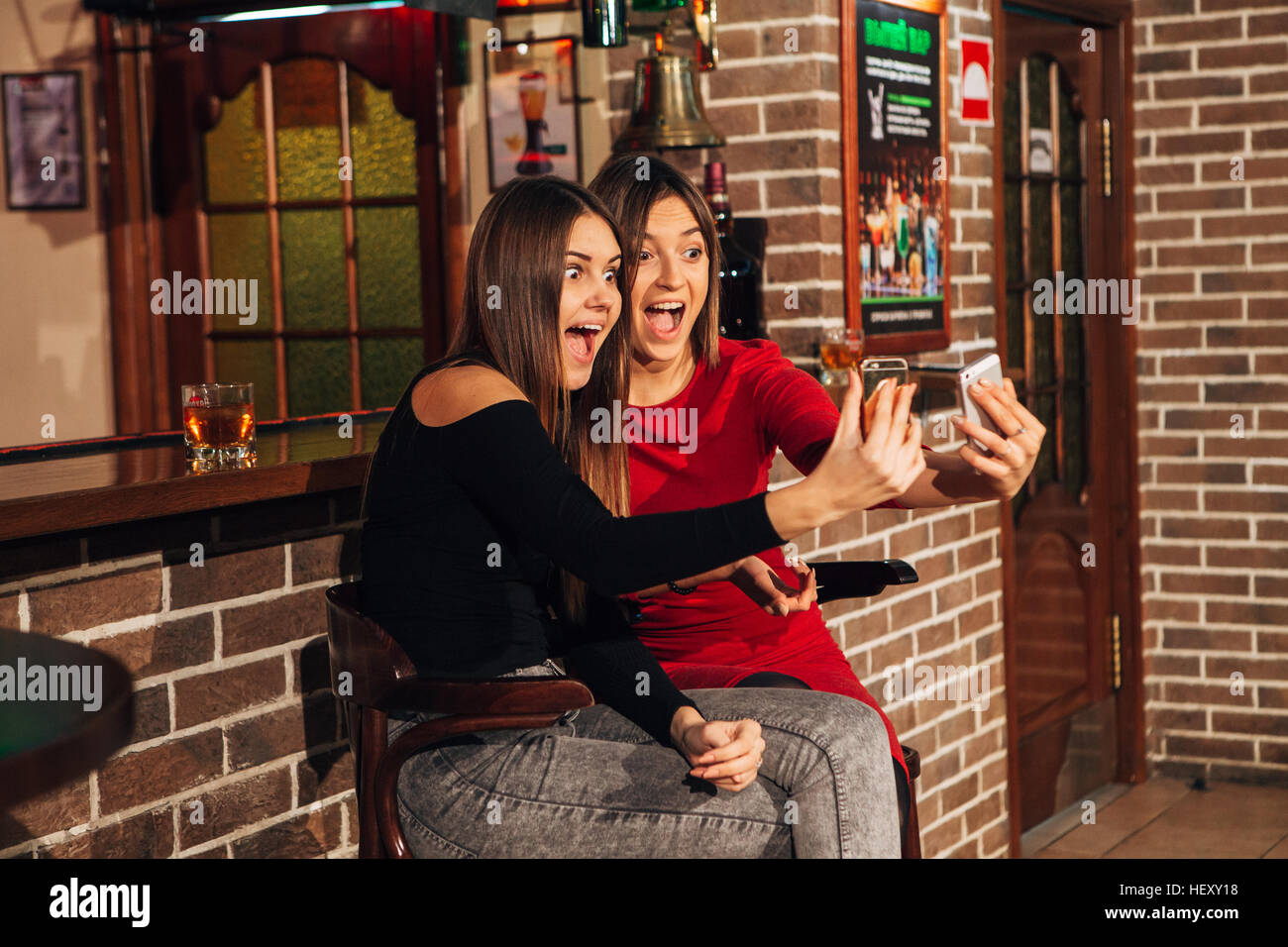 two beautiful women take a selfie at the bar Stock Photo - Alamy