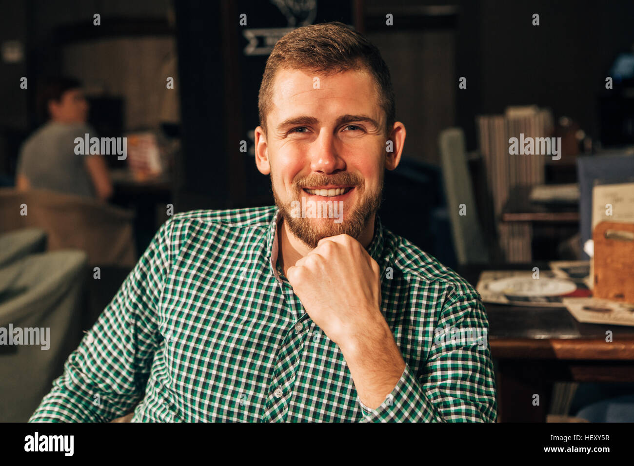 young man in restaurant smiling Stock Photo - Alamy