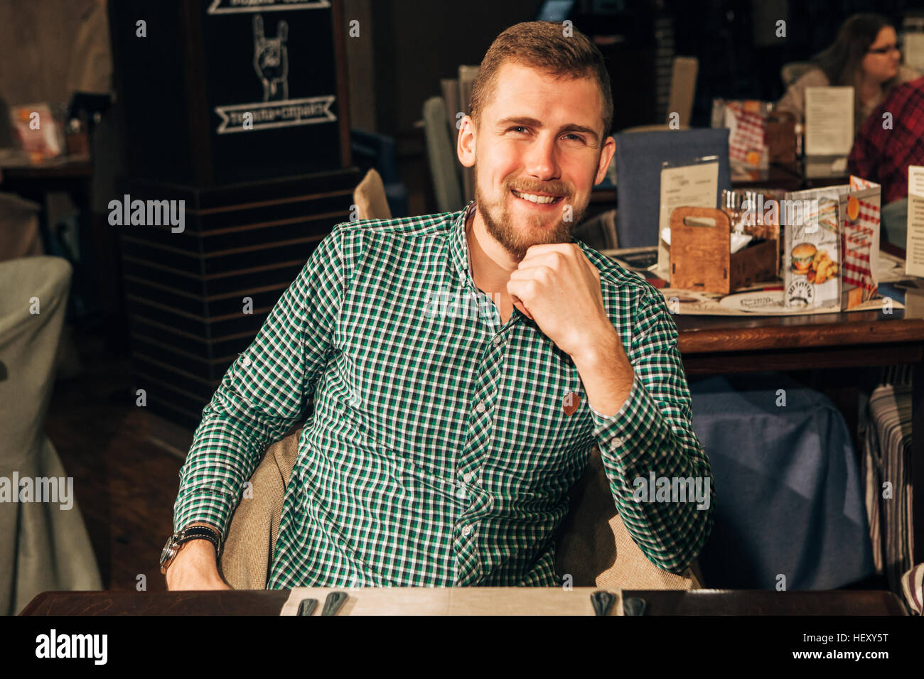 young man in restaurant smiling Stock Photo - Alamy