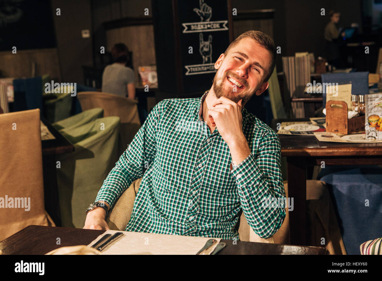 young man in restaurant smiling Stock Photo - Alamy