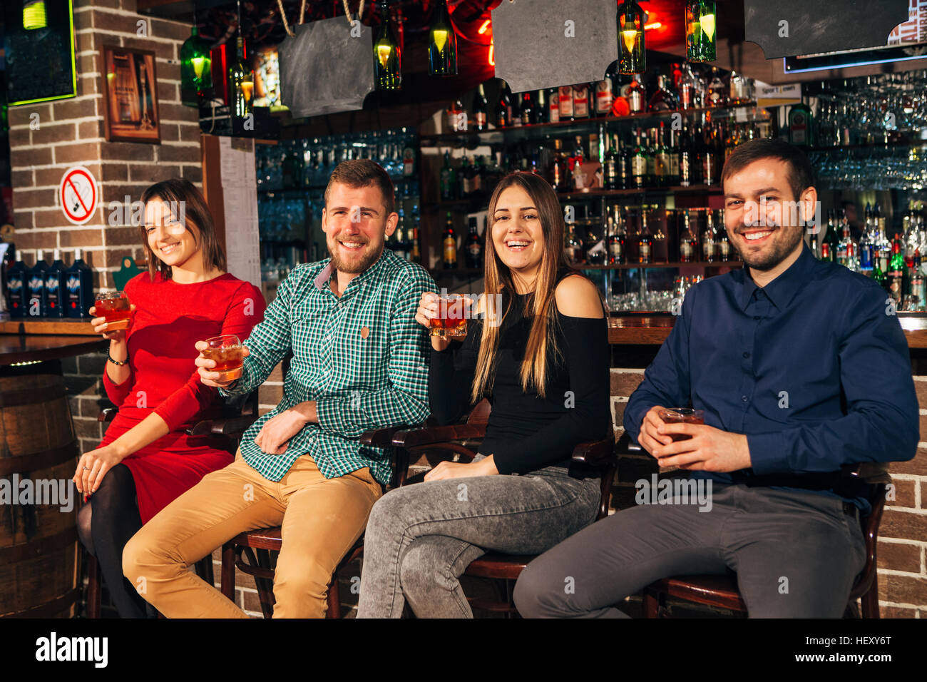 company of two couples resting at the bar and drinks Stock Photo - Alamy