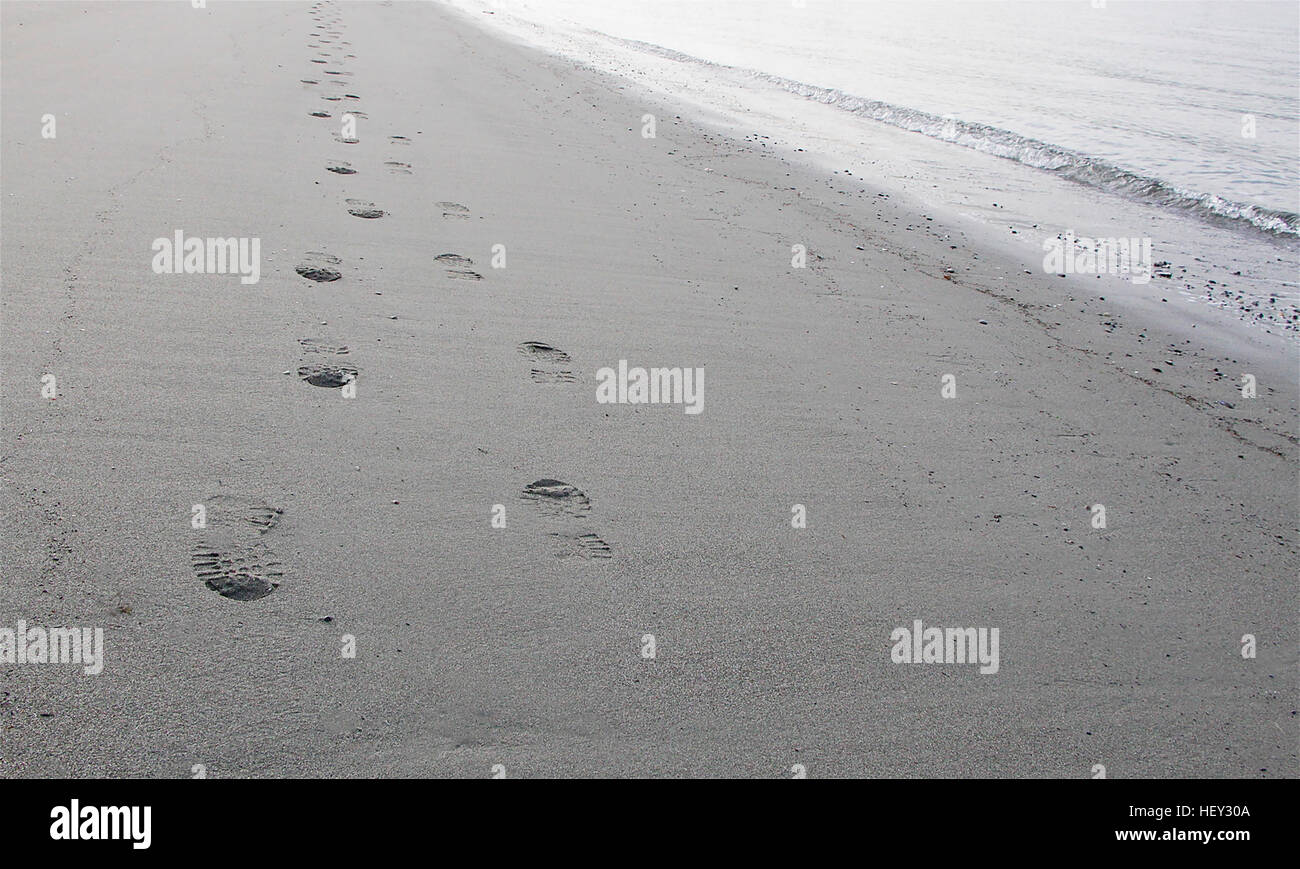 Single footsteps in sandy beach Stock Photo - Alamy