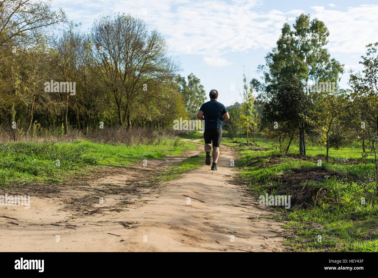 Big belly man jogging , exercising, doing cardio in the park , slightly ...