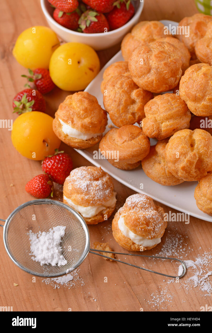cream puffs stuffed decorated with pieces of fruit Stock Photo - Alamy