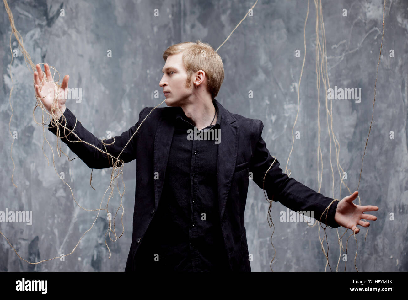 Young man tries to break the shackles. Concept of manipulation and ...