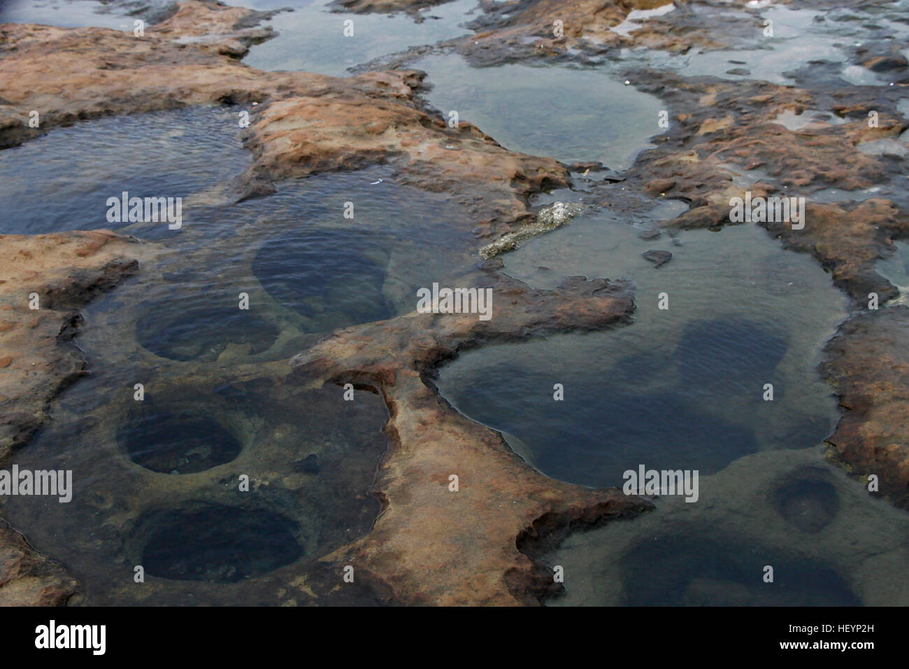 Alien pools of water in holes over rocky landscape Stock Photo - Alamy