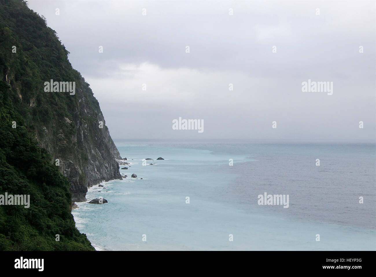 Cliff face and shallow coast with blue waters Stock Photo - Alamy