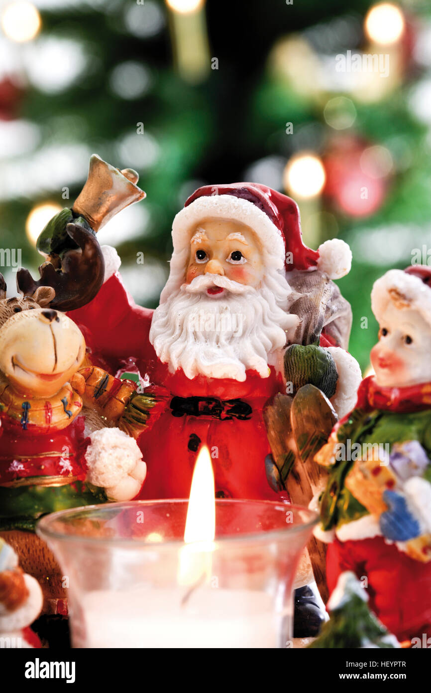 Tea light in clear glass holder in front of Santa Claus figurine Stock ...