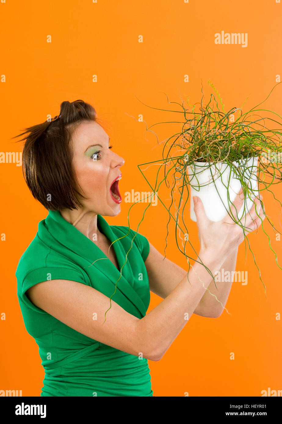 Young woman screaming at a potted plant Stock Photo - Alamy