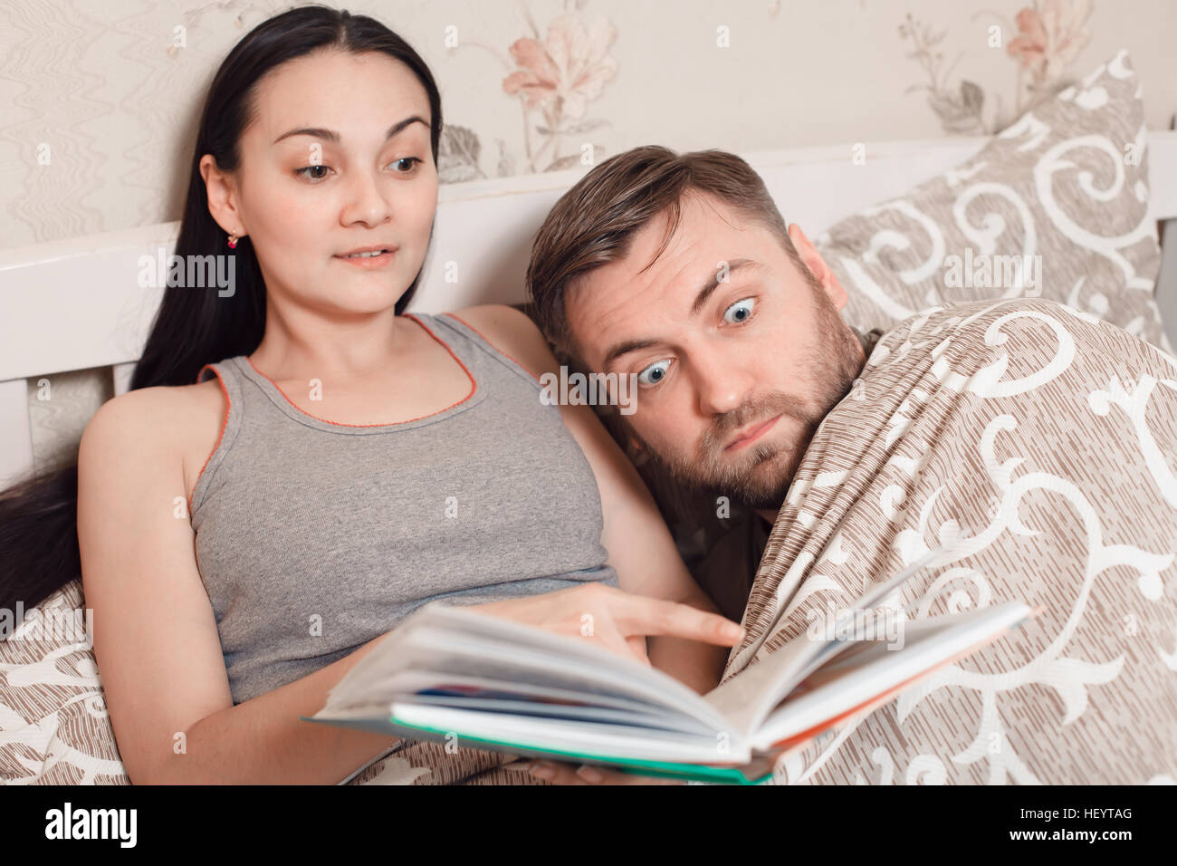 Couple reading a book before sleep Stock Photo - Alamy