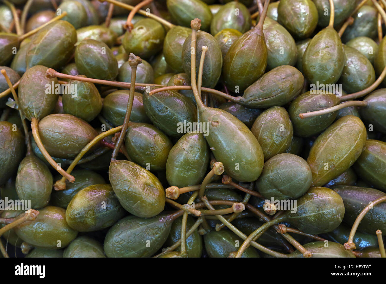 Green pickled big capers (fruits, berries, caperberries) close up ...