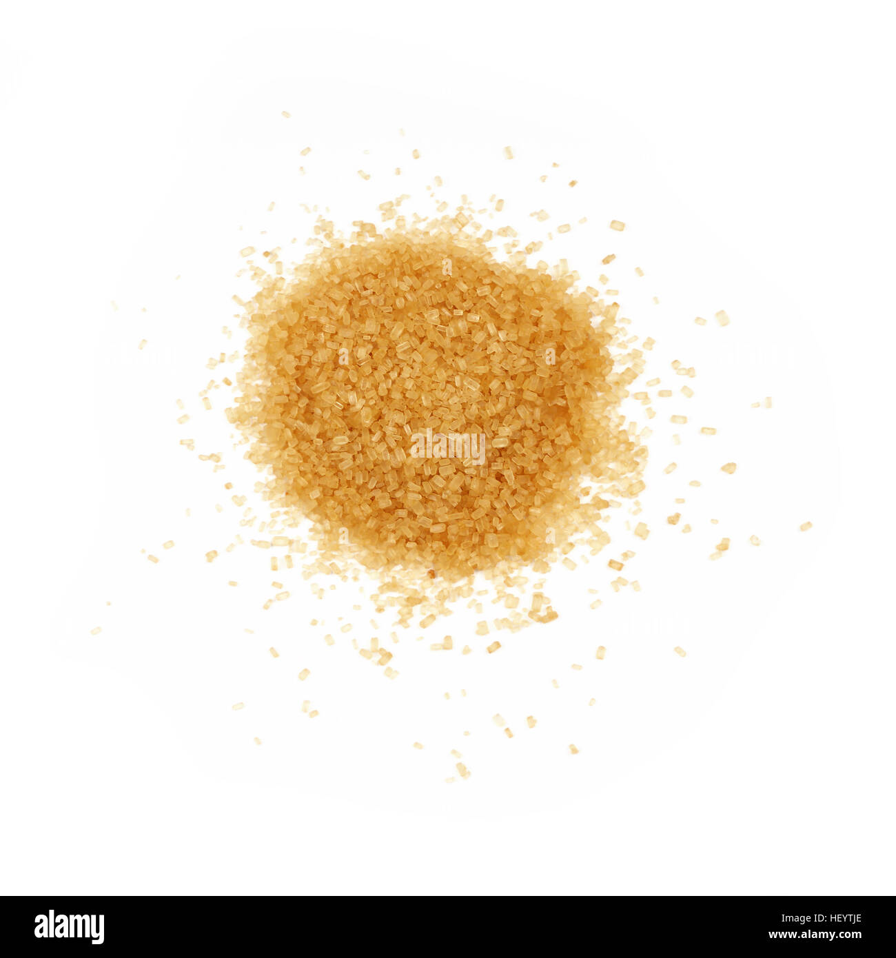 Pinch of brown cane sugar spilled around isolated on white background ...